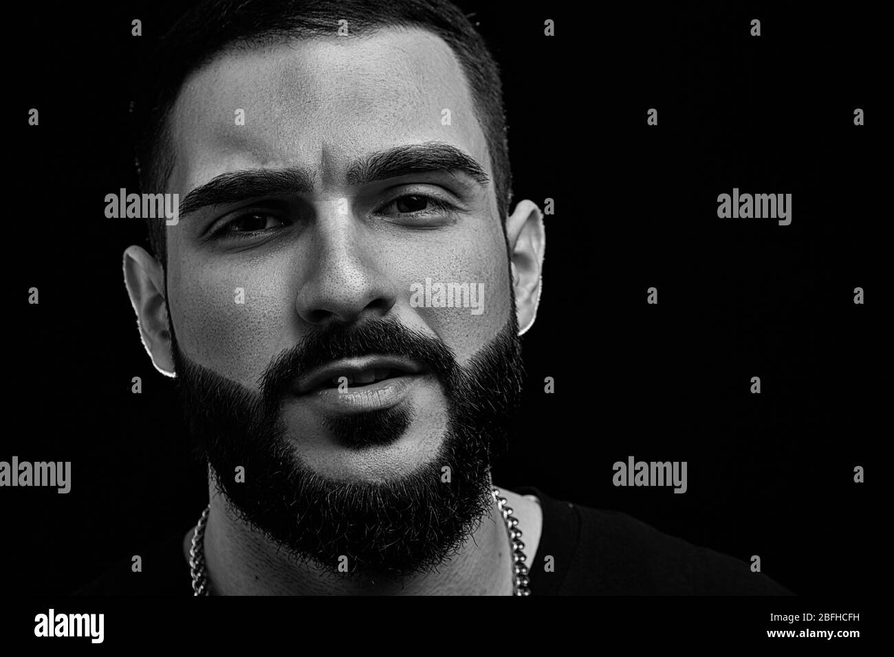 close-up of a dramatic portrait of a young serious guy, musician ...