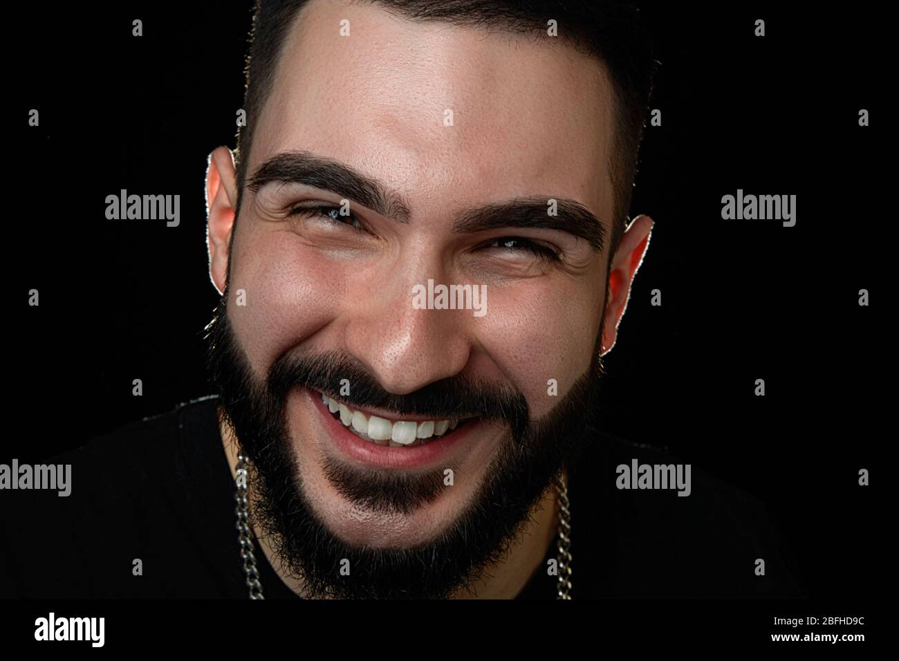 close-up of a dramatic portrait of a smiling young guy, a musician ...