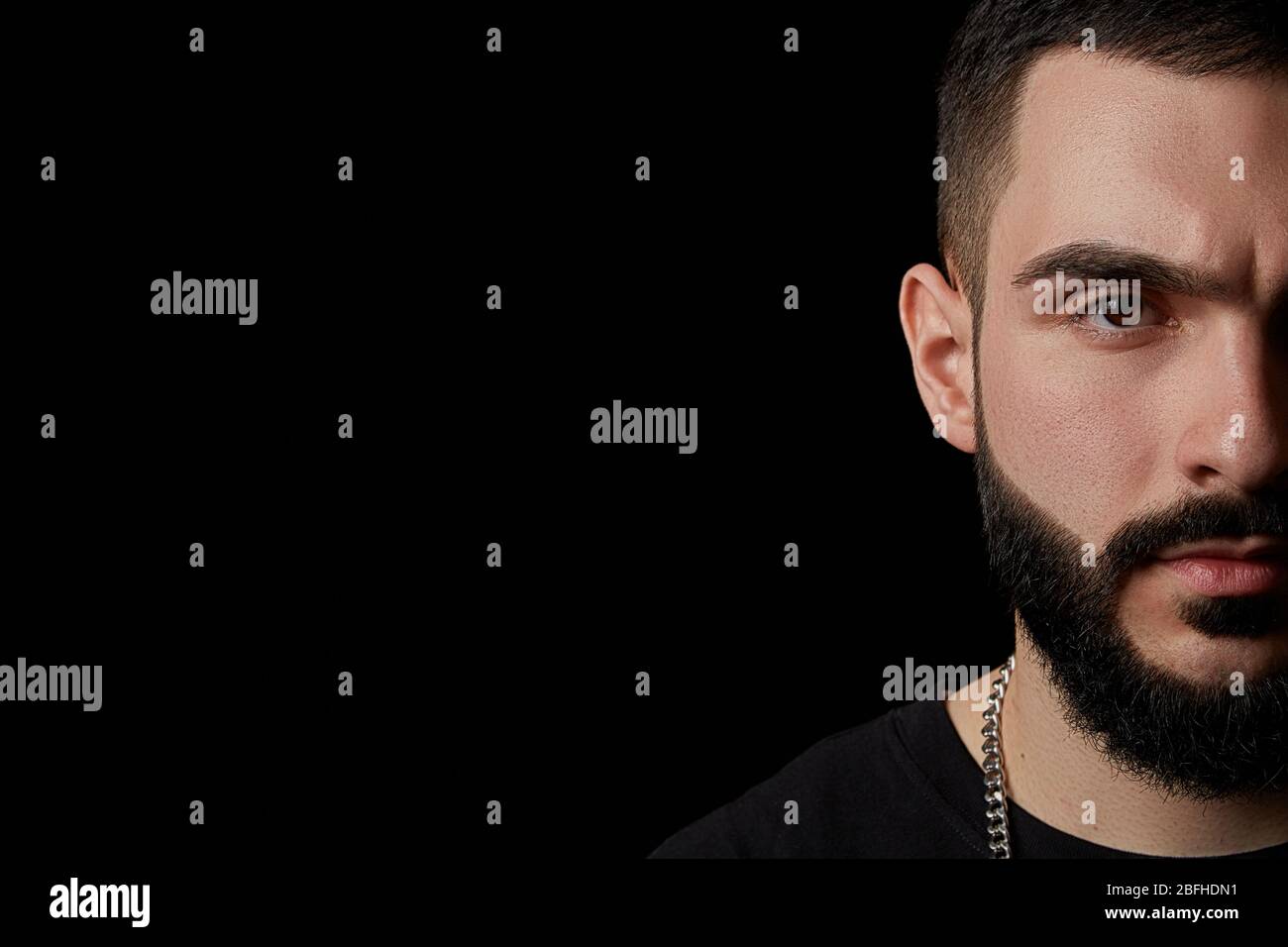 close-up of a dramatic portrait of a young serious guy, a musician ...