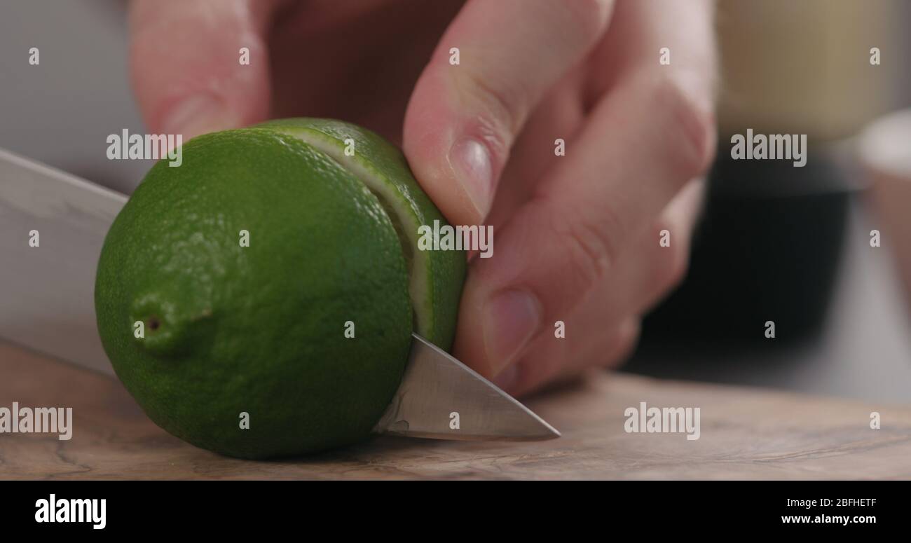 man hands cutting lime in half with knife Stock Photo - Alamy