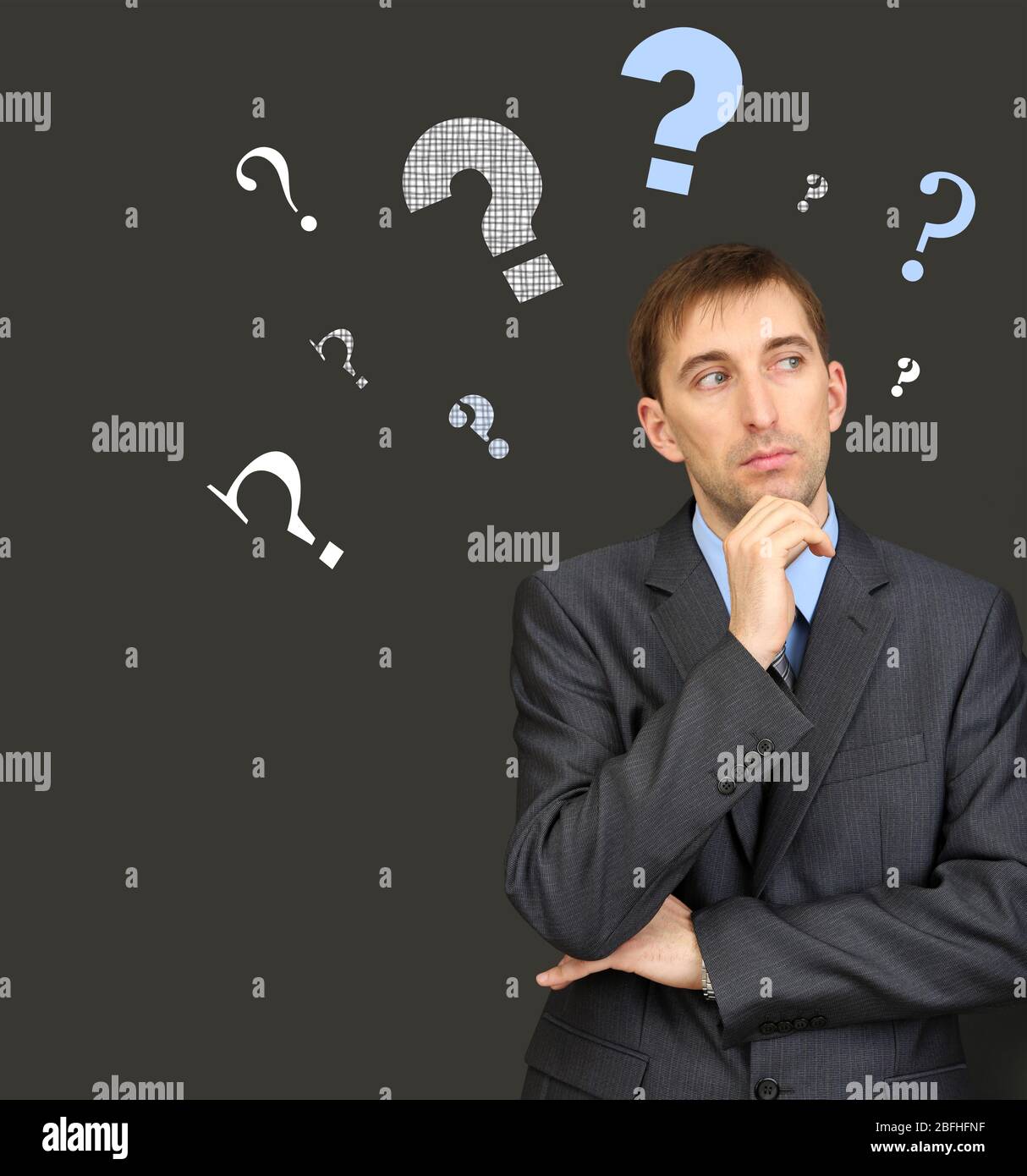 Man thinking surrounded by question on dark background Stock Photo - Alamy