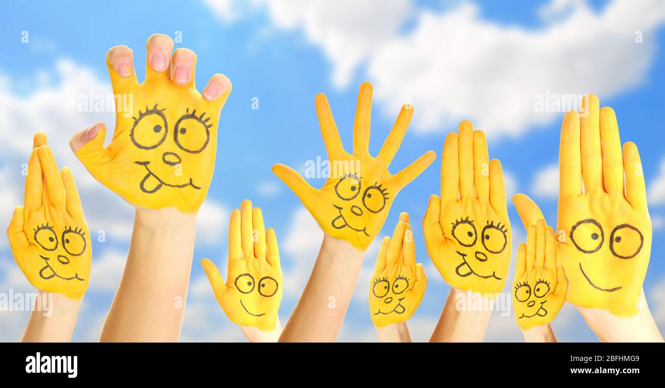 Painted hands with smile on sky background Stock Photo - Alamy