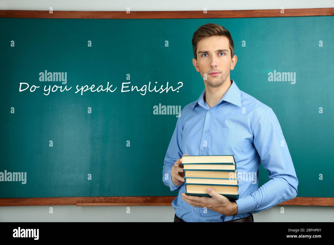 Young teacher with books near chalkboard in school classroom Stock ...