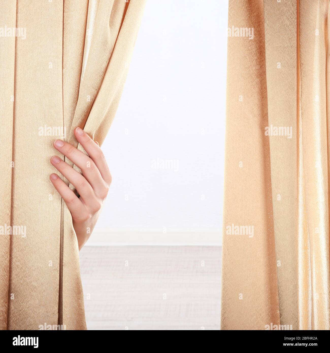 Hand opening curtain on wall background Stock Photo - Alamy