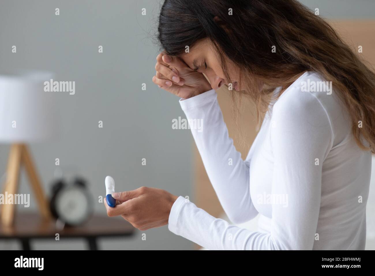 Unhappy stressed woman crying, feeling depressed, holding pregnancy ...