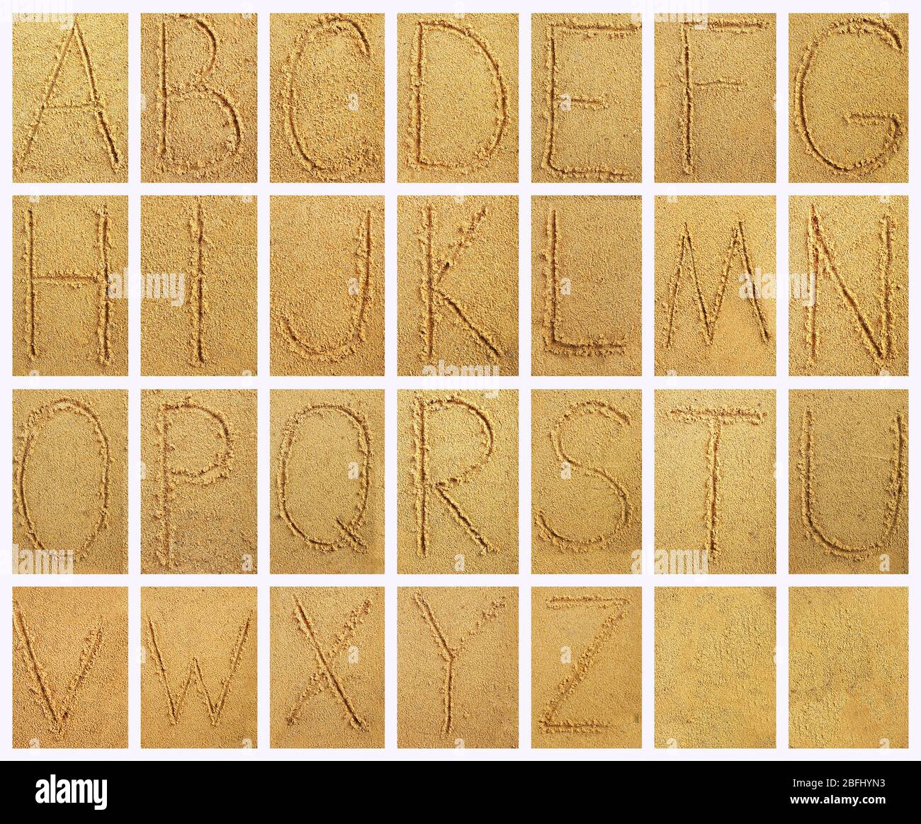 Handwritten alphabet letters on sand background Stock Photo - Alamy