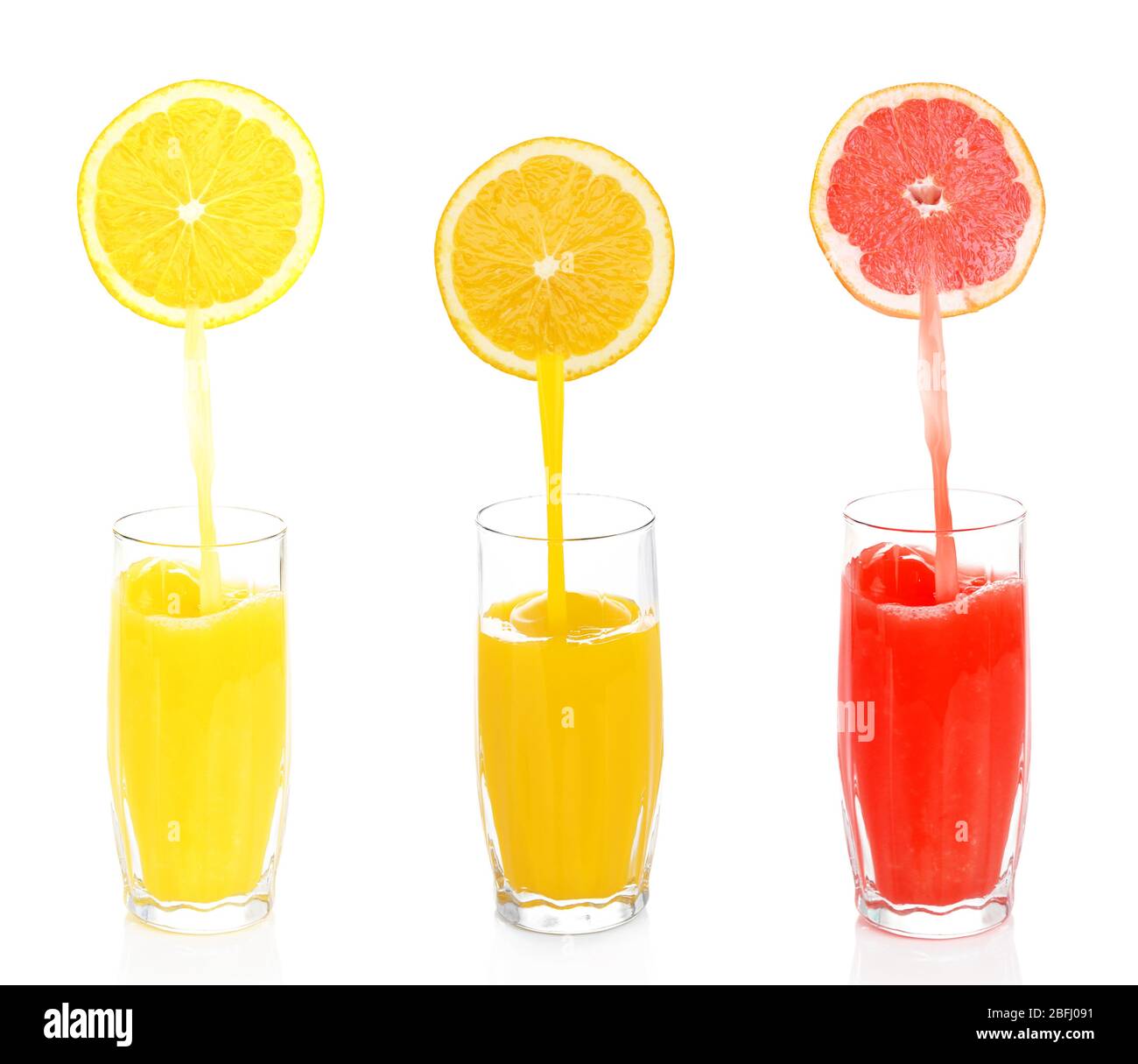 Juice pouring from fruits into glass, isolated on white Stock Photo - Alamy