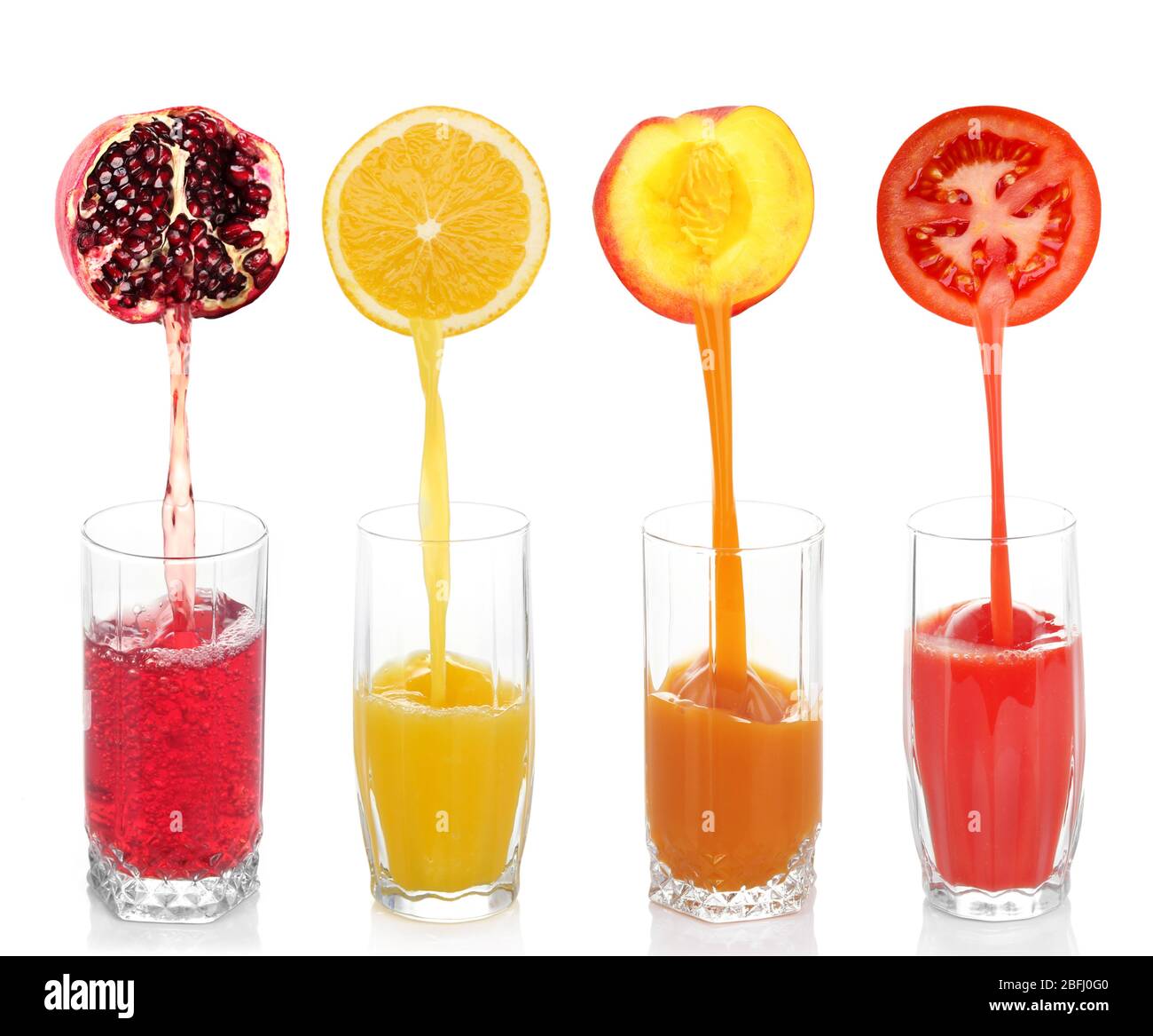 Juice pouring from fruits and vegetables into glass, isolated on white ...