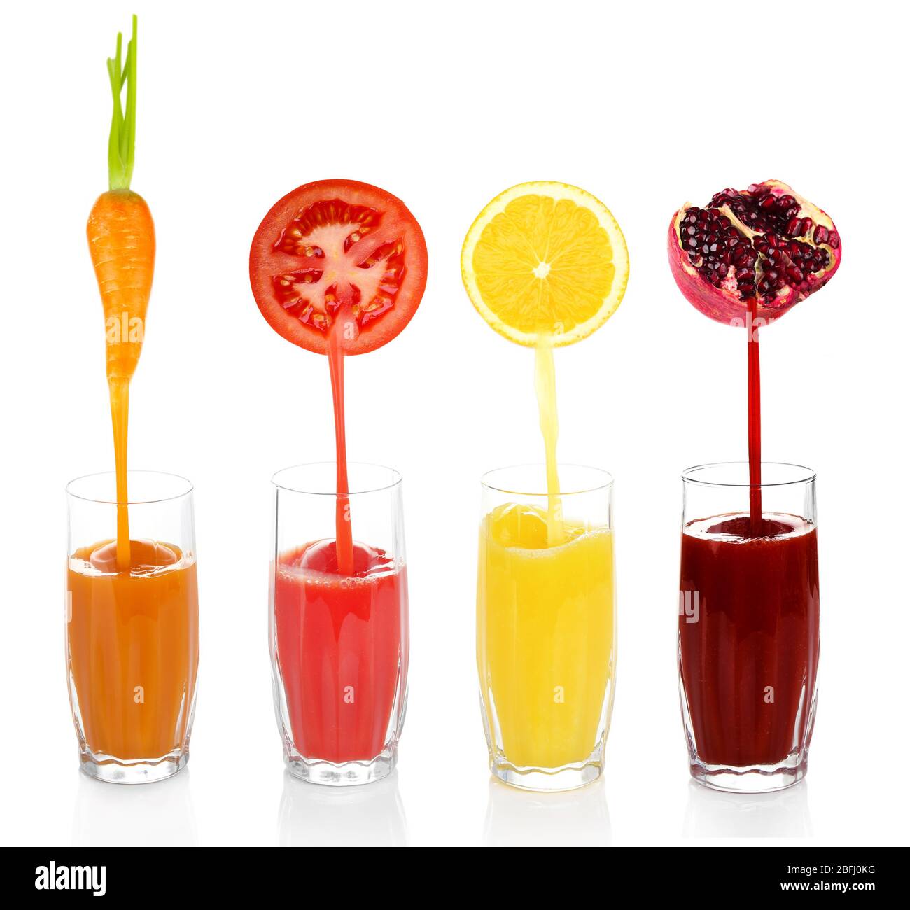 Juice pouring from fruits and vegetables into glass, isolated on white ...