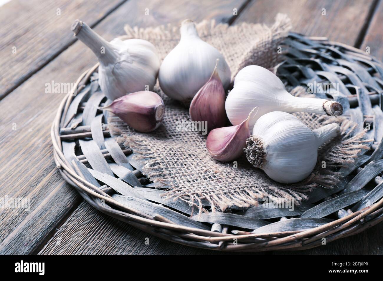 Fresh garlic on wicker mat, on wooden background Stock Photo - Alamy