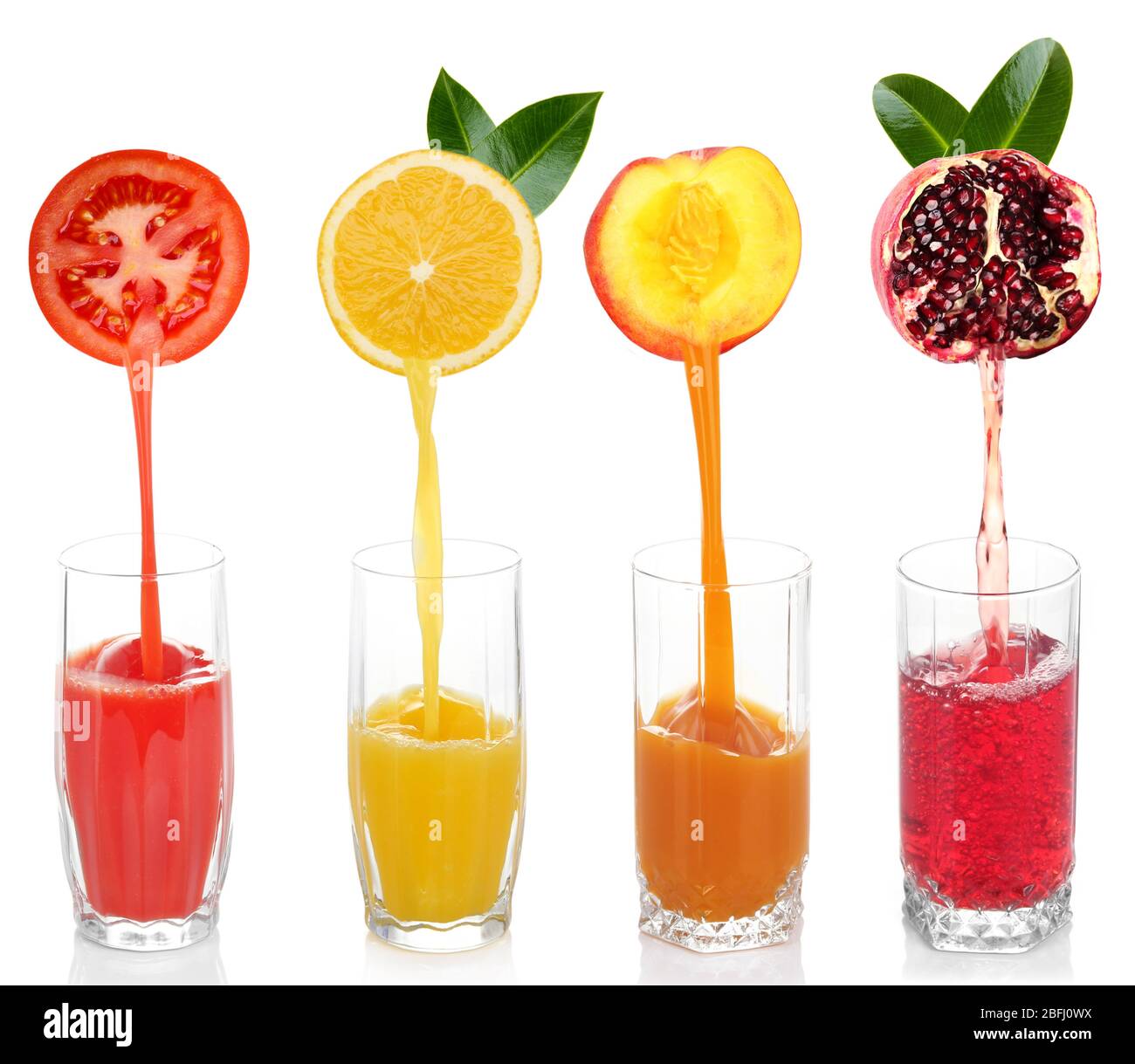 Juice pouring from fruits and vegetables into glass, isolated on white ...