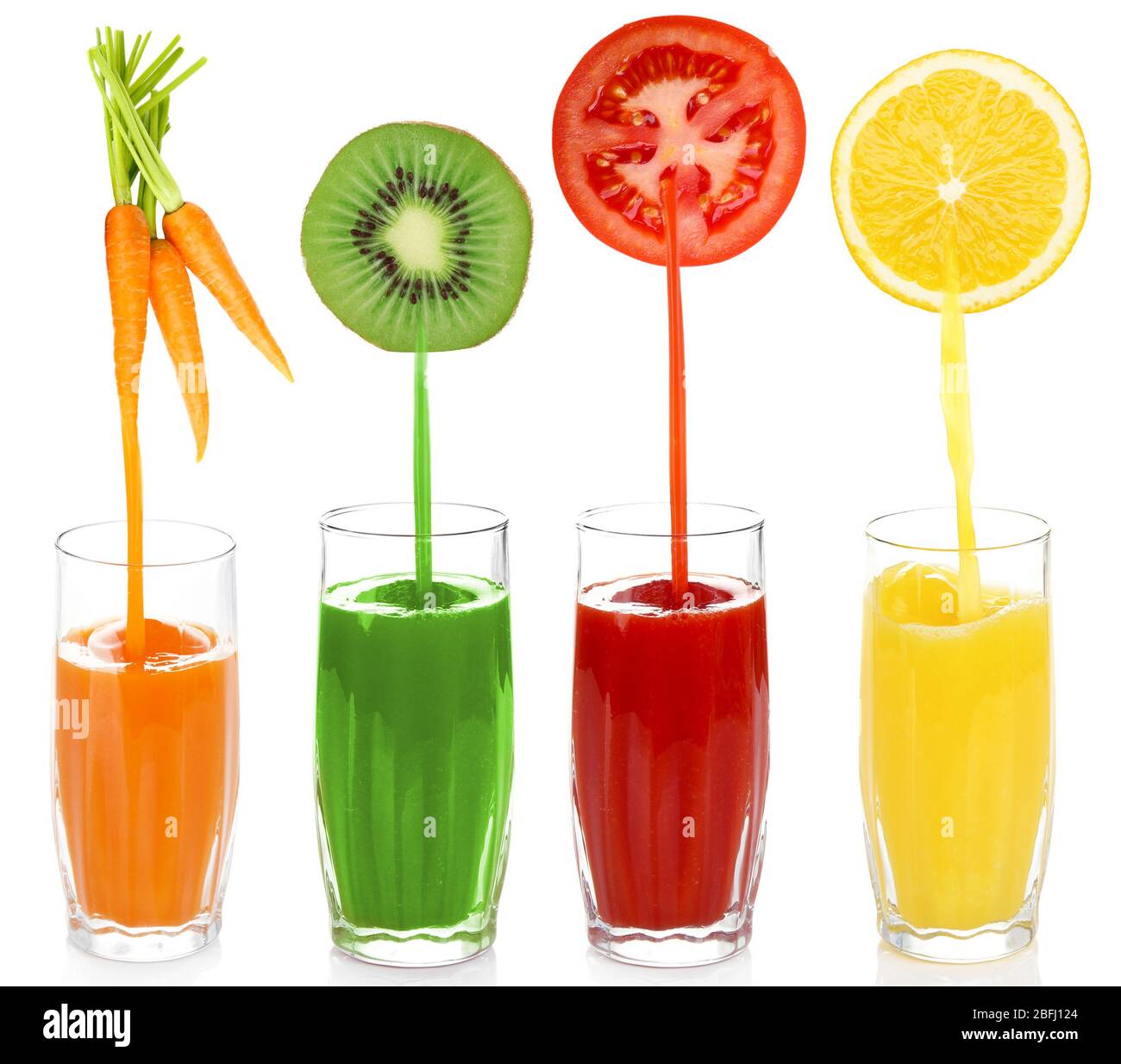 Juice pouring from fruits and vegetables into glass, isolated on white ...