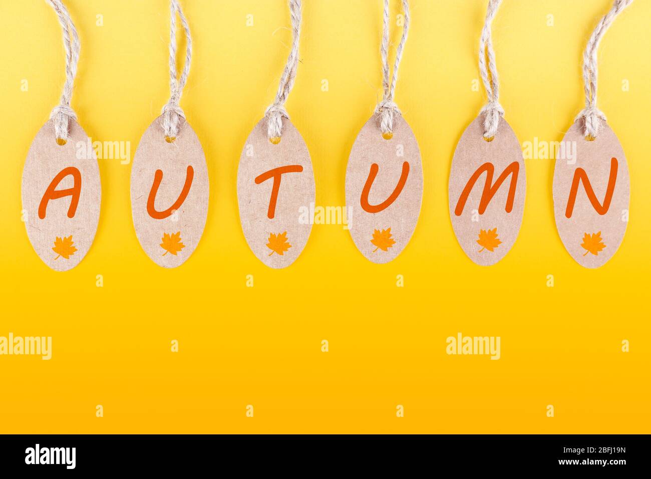 Autumn tags on yellow background Stock Photo - Alamy