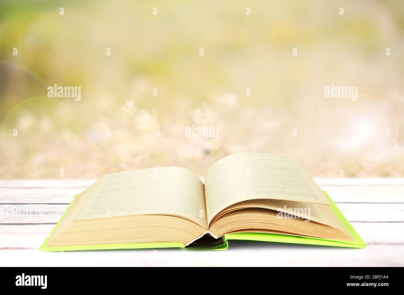 Open book on table outdoors Stock Photo - Alamy