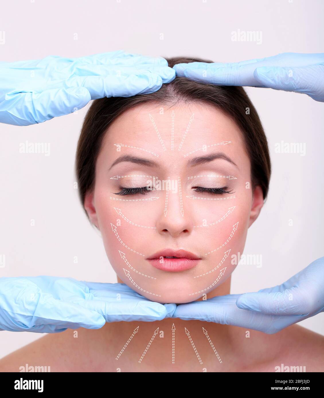 Face massage. Hands in rubber gloves touching face of young woman (with ...