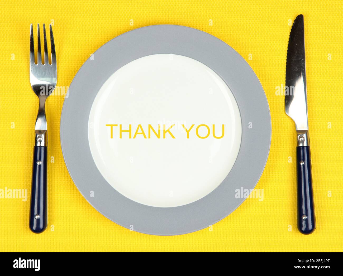 Plate with text Thank You, fork and knife on tablecloth background ...