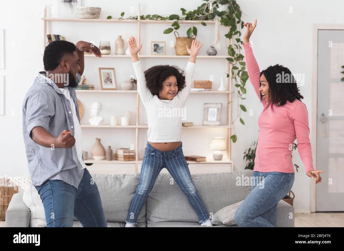 Joyful black family of three dancing dancing together at home Stock ...