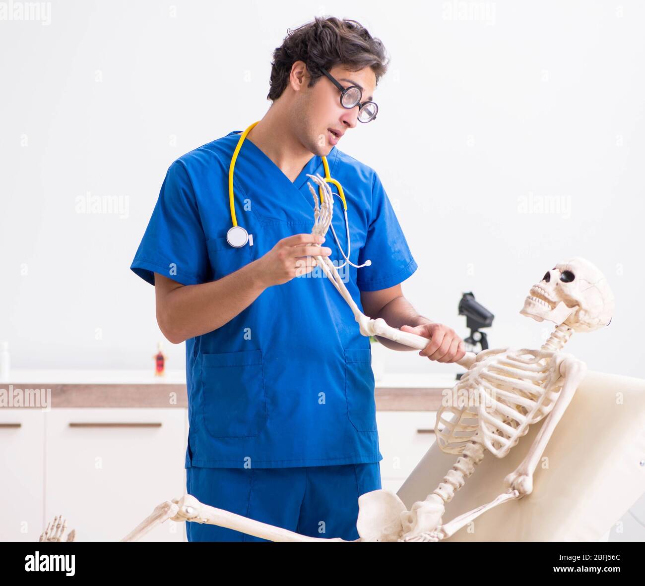 The funny doctor with skeleton in hospital Stock Photo - Alamy