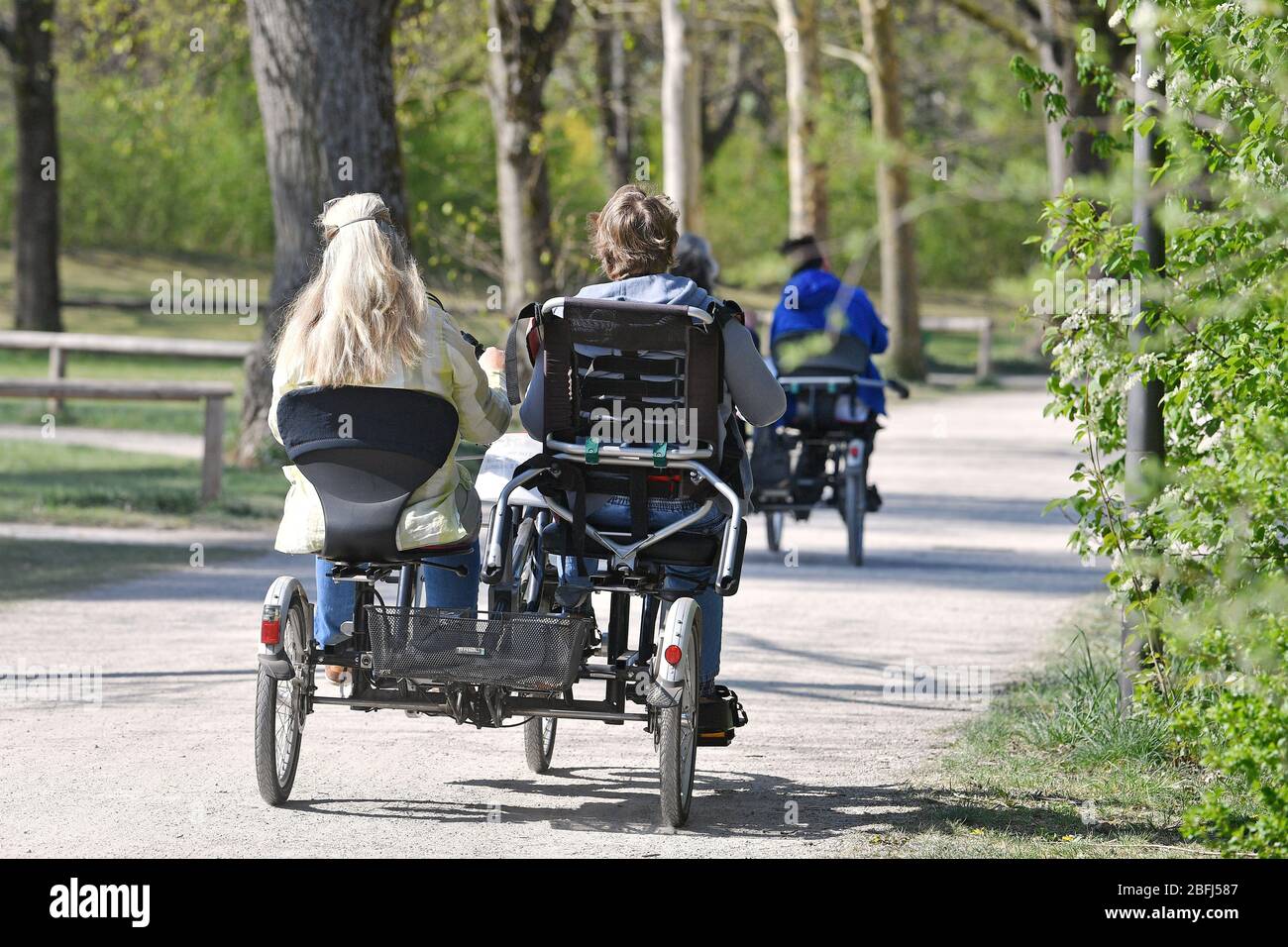 Munich, Deutschland. 18th Apr, 2020. Two people ride together on a two ...
