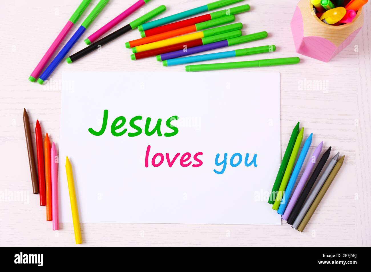 Jesus loves you text on paper on table background Stock Photo - Alamy