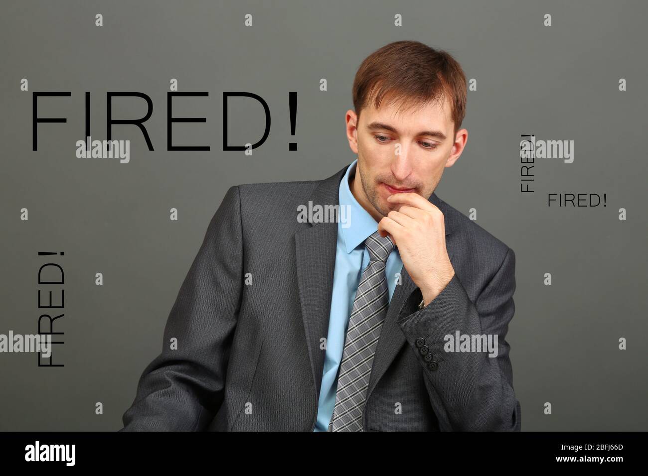 Sad fired office worker on gray wall background Stock Photo - Alamy
