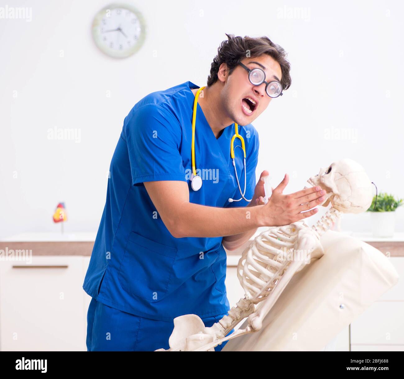 The funny doctor with skeleton in hospital Stock Photo - Alamy