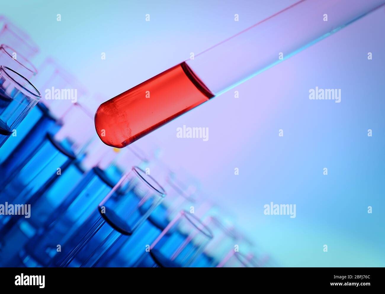 Test tube filled with red liquid on background of other tubes, close-up ...