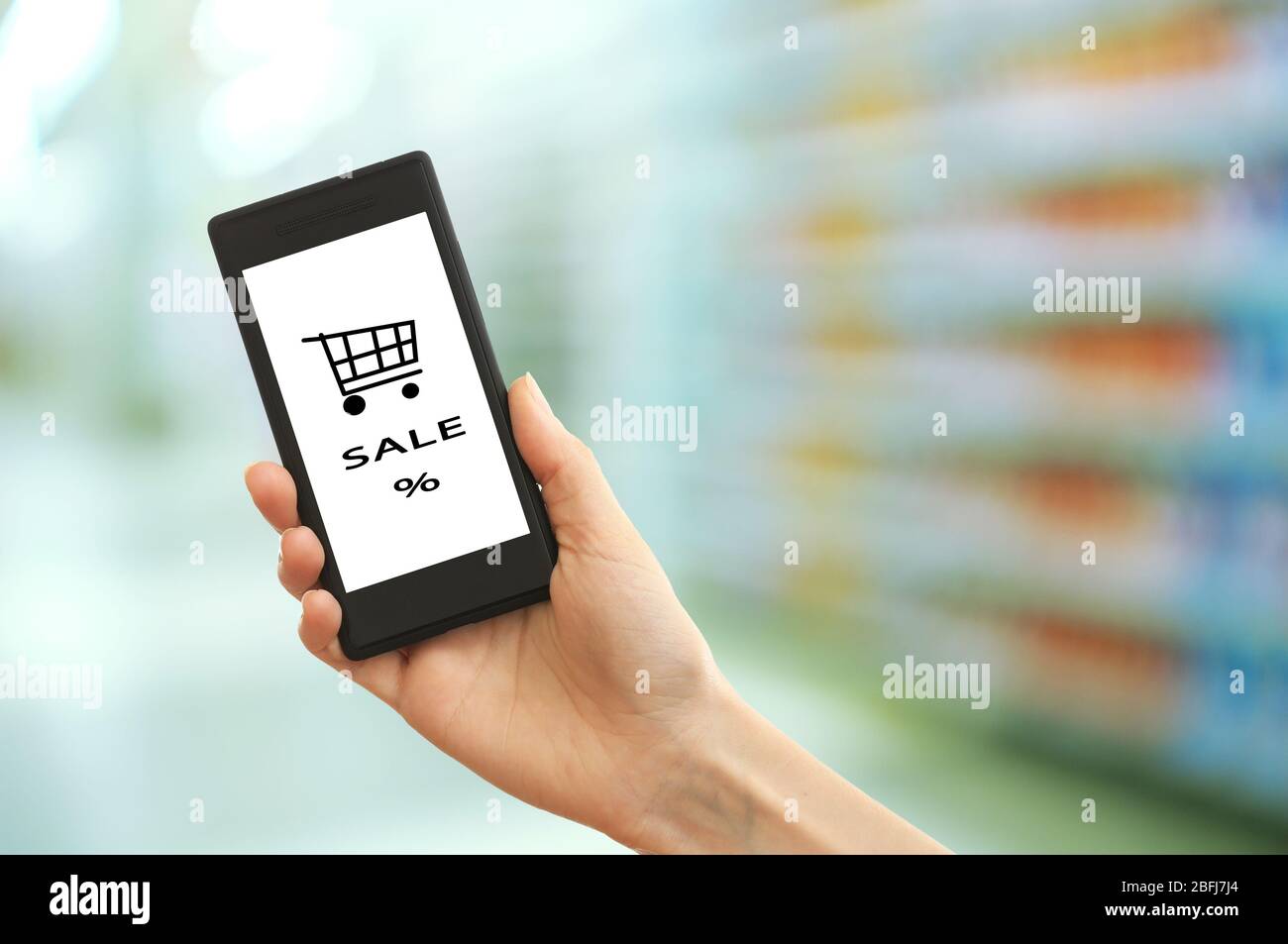 Mobile shopping concept. Hand holding mobile phone for internet ...
