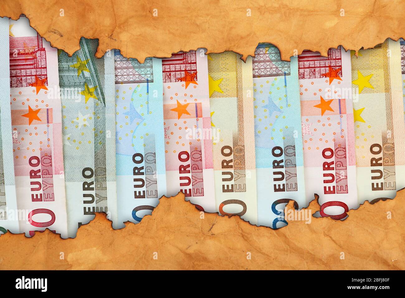 Euro banknotes in torn craft paper frame Stock Photo - Alamy