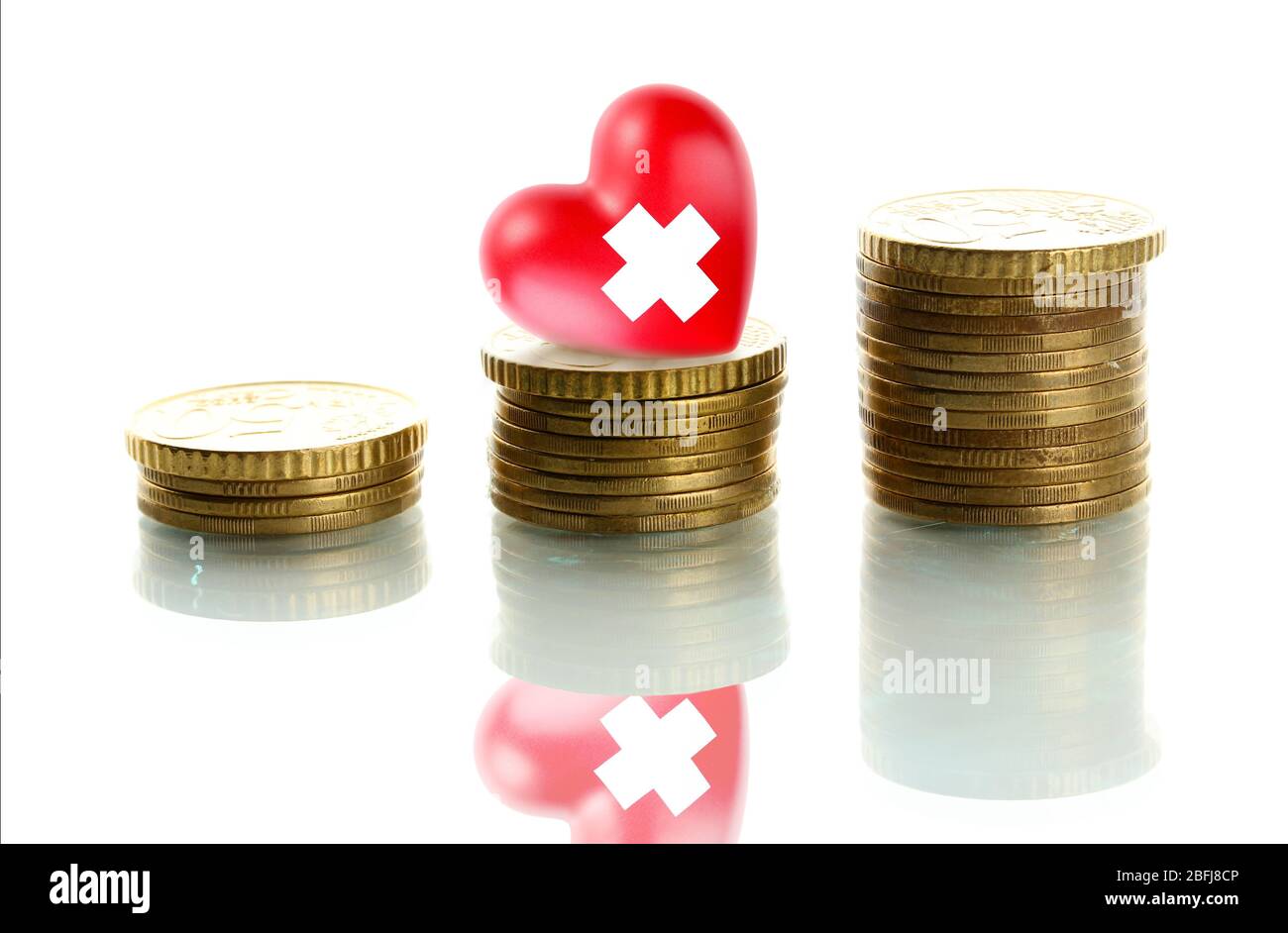 Red heart with cross sign on stack of coins isolated on white Stock ...