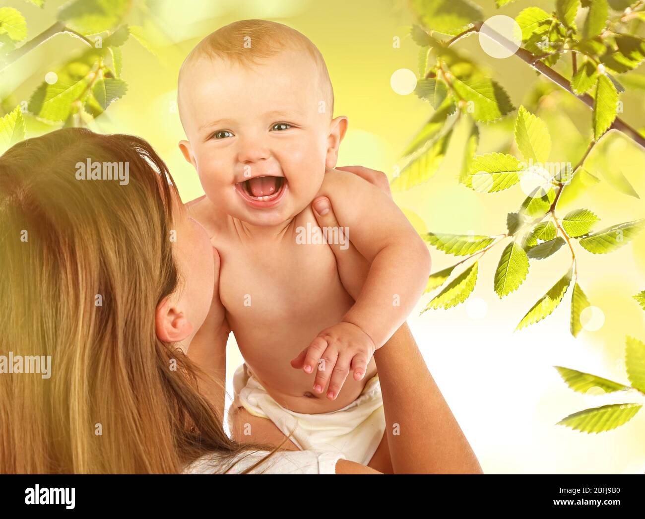 Cute baby boy and his mother on natural background Stock Photo - Alamy