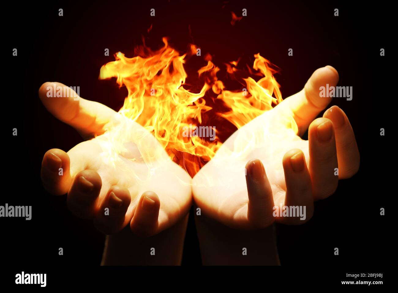 Hands with fire isolated on black Stock Photo - Alamy