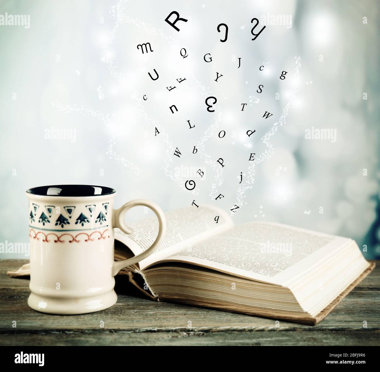 Open book with flying letters on table on bright background Stock Photo ...