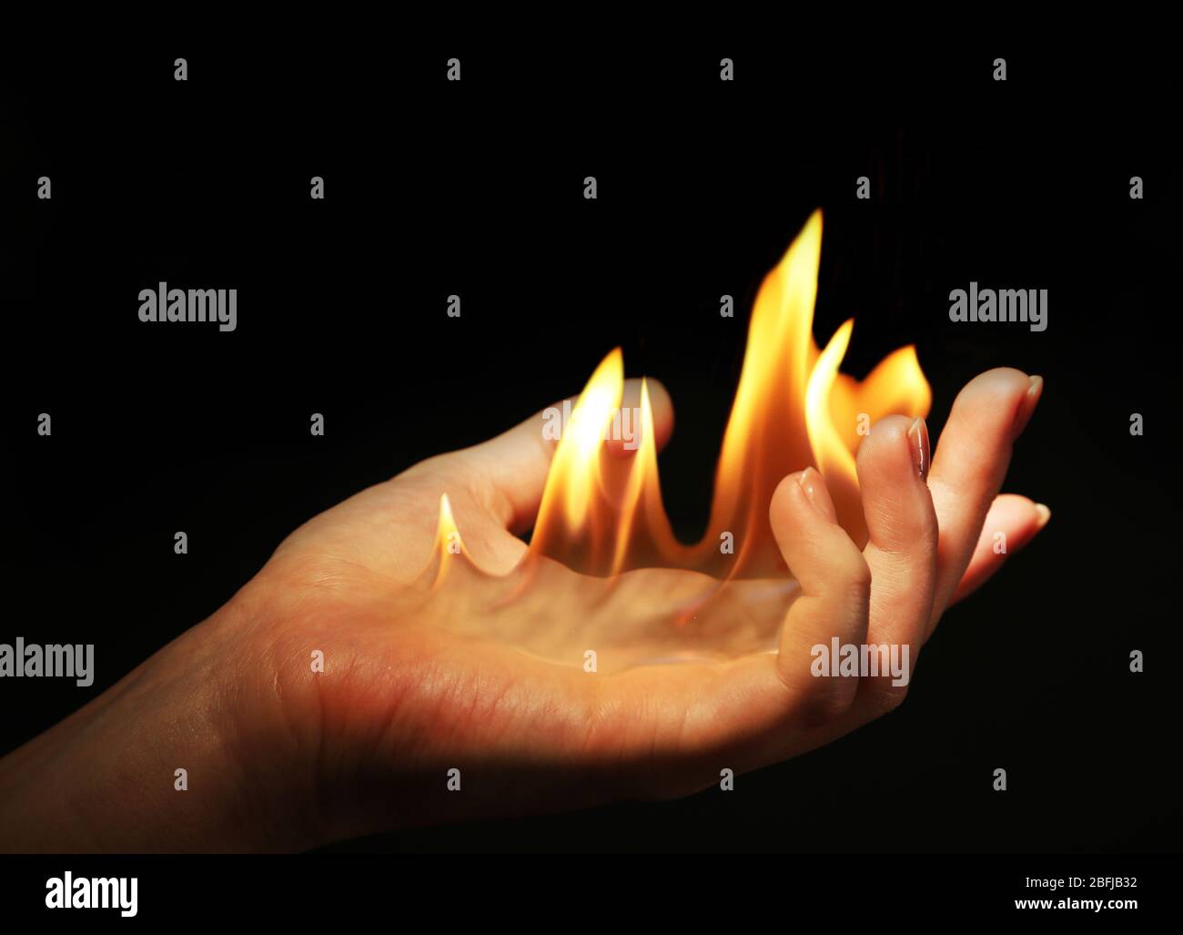 Hand with fire isolated on black Stock Photo - Alamy