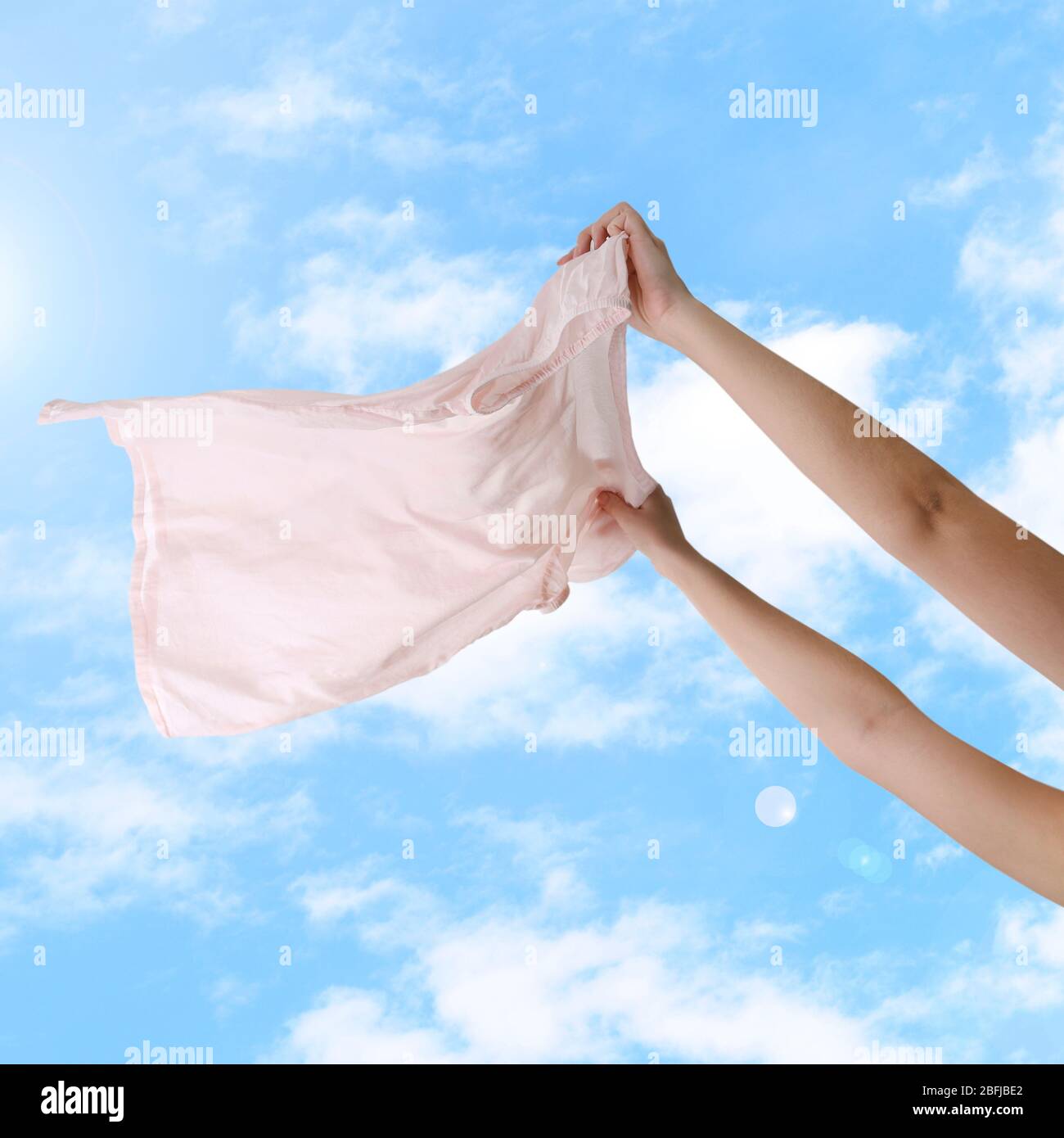 Hands holding flying shirt on sky background Stock Photo - Alamy