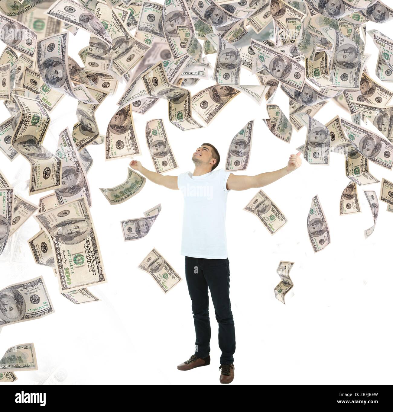 Young man standing in rain of money Stock Photo - Alamy
