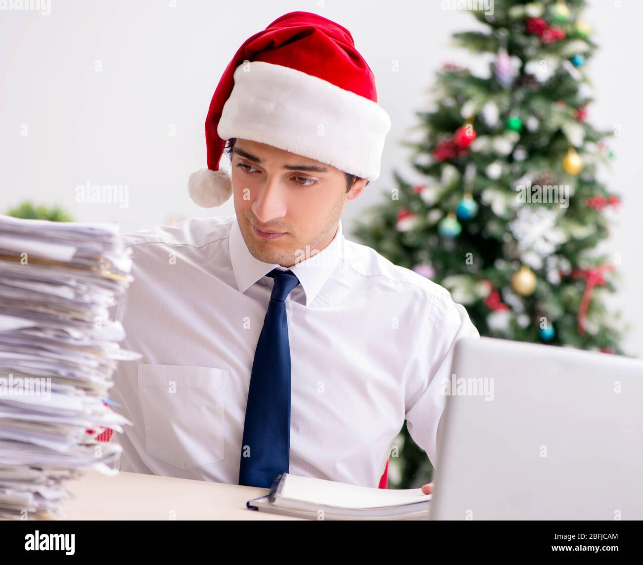 The young worker working in office on christmas shift Stock Photo - Alamy