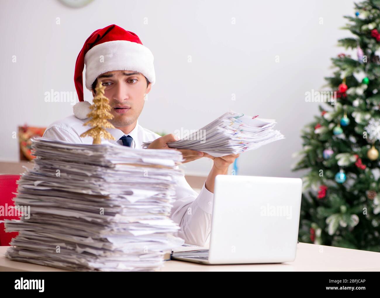 The young worker working in office on christmas shift Stock Photo - Alamy
