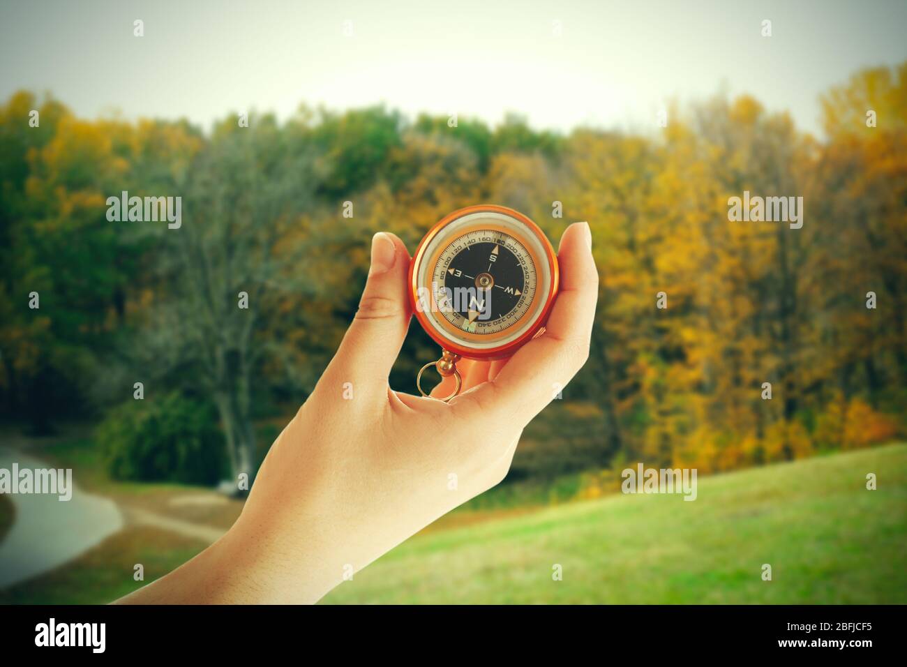 Human hand with compass on nature background Stock Photo - Alamy