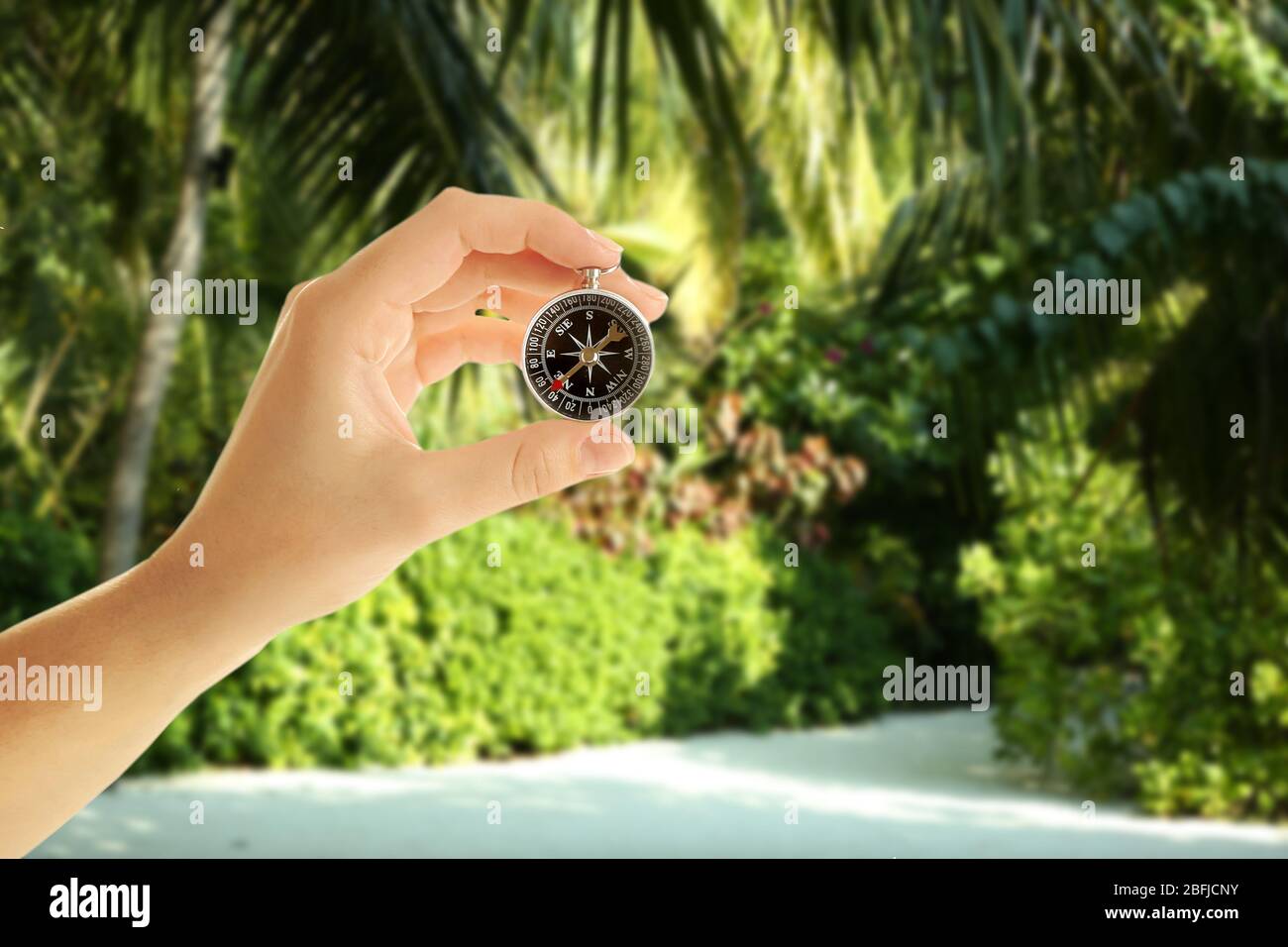 Human hand with compass on nature background Stock Photo - Alamy