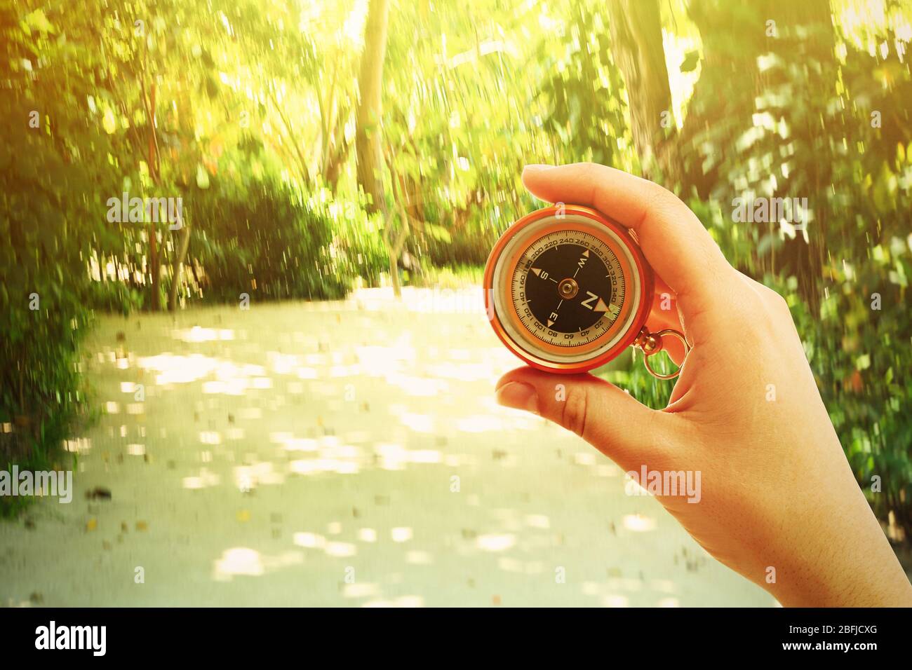 Human hand with compass on nature background Stock Photo - Alamy
