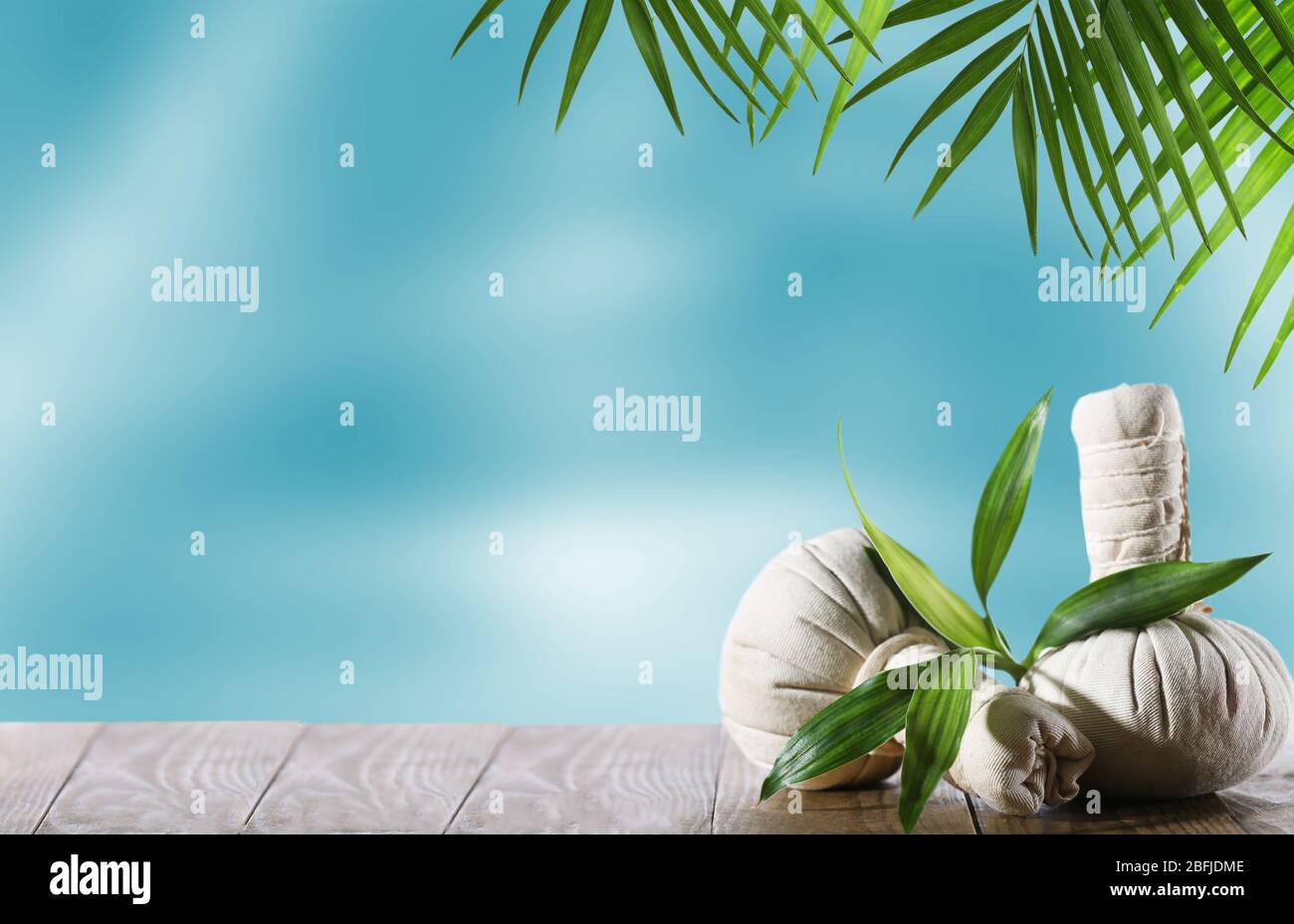 Spa compress balls with leaves on blue background Stock Photo - Alamy