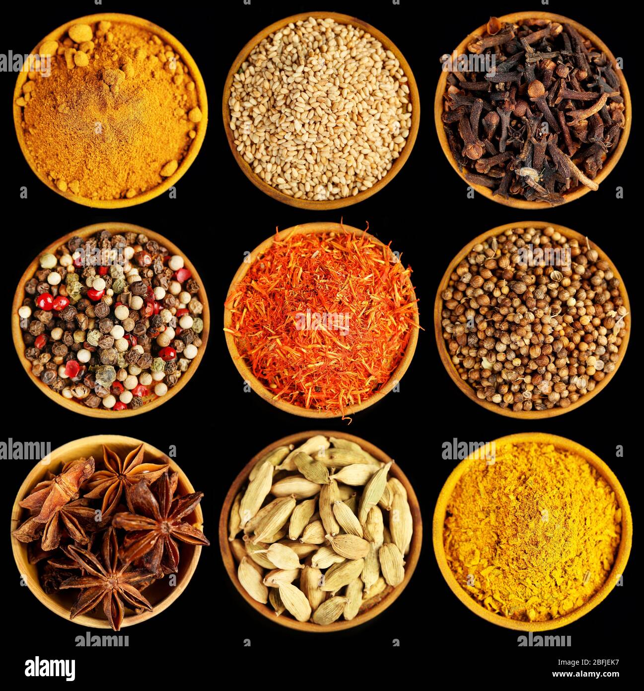 Different spices on black background Stock Photo - Alamy