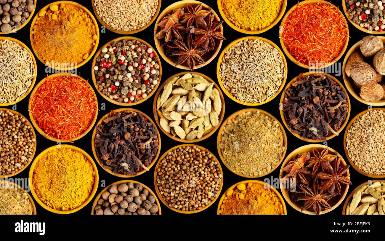 Different spices on black background Stock Photo - Alamy