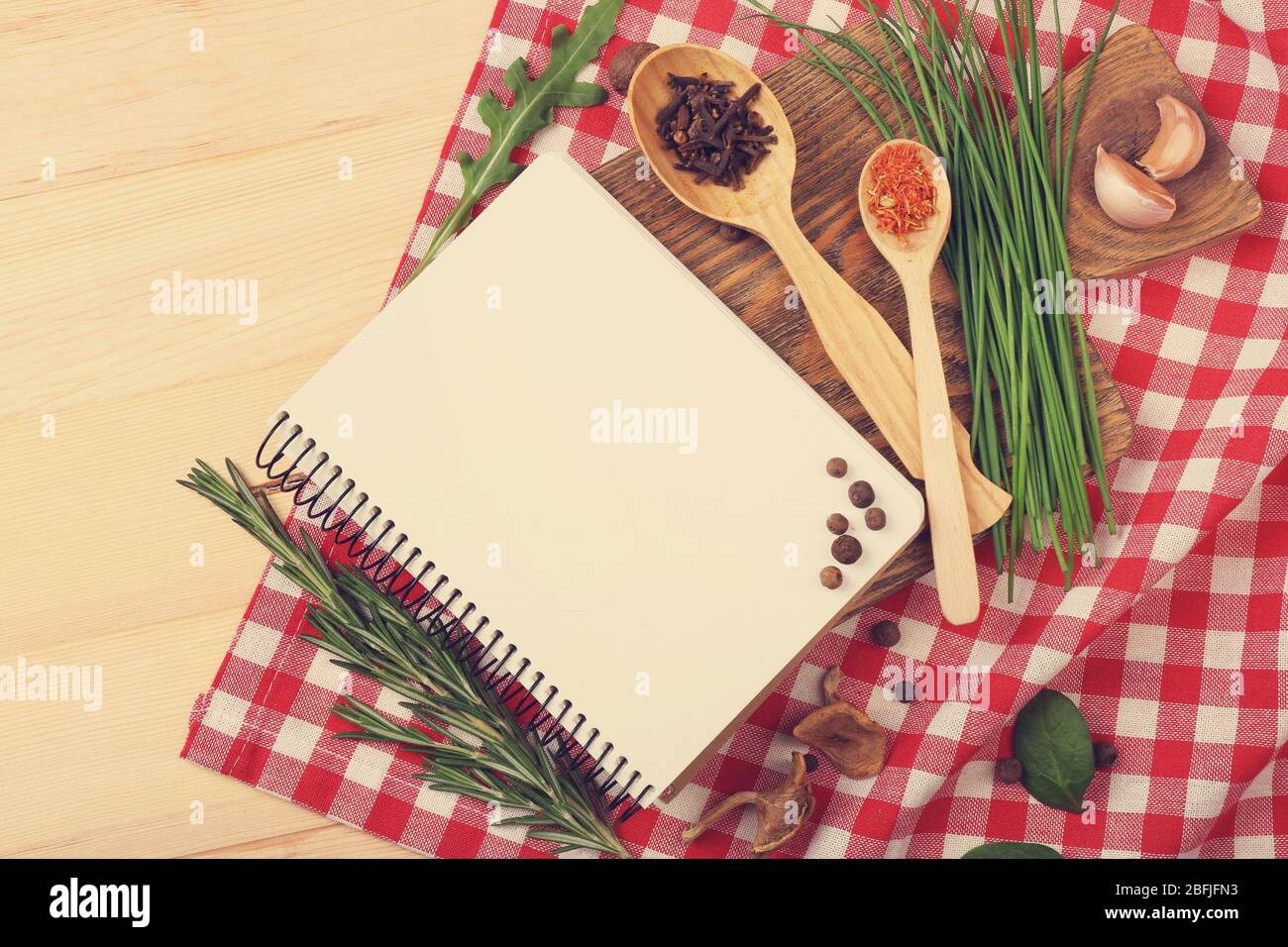 Recipe book page with different herbs on napkin wooden background Stock ...