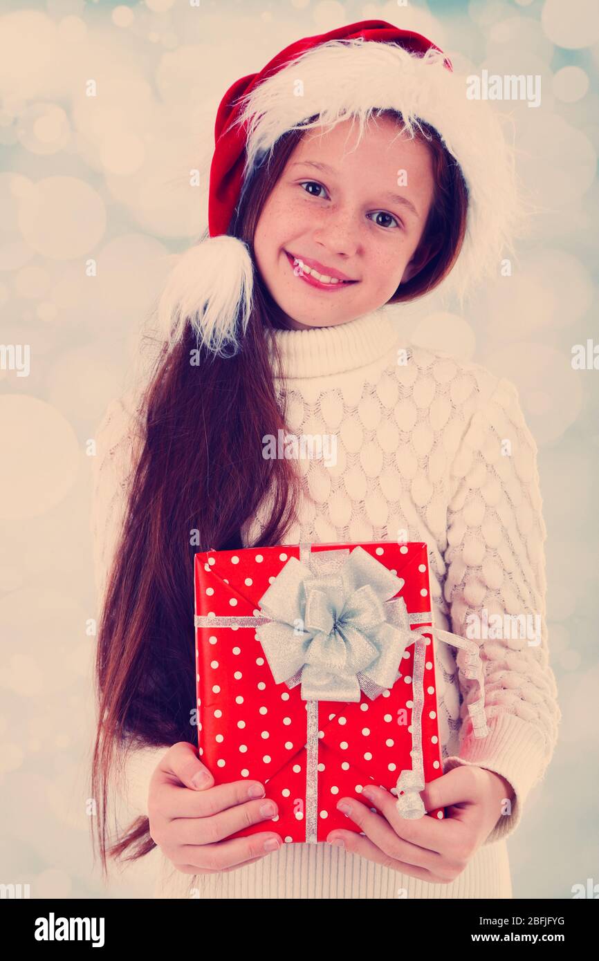 Beautiful little girl with present box on bright background Stock Photo ...