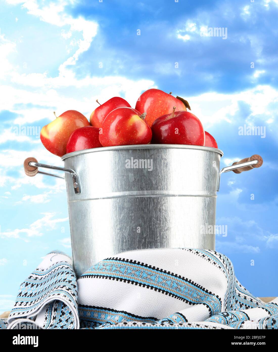 Pail filled with red apples and dishcloth on sky background Stock Photo ...