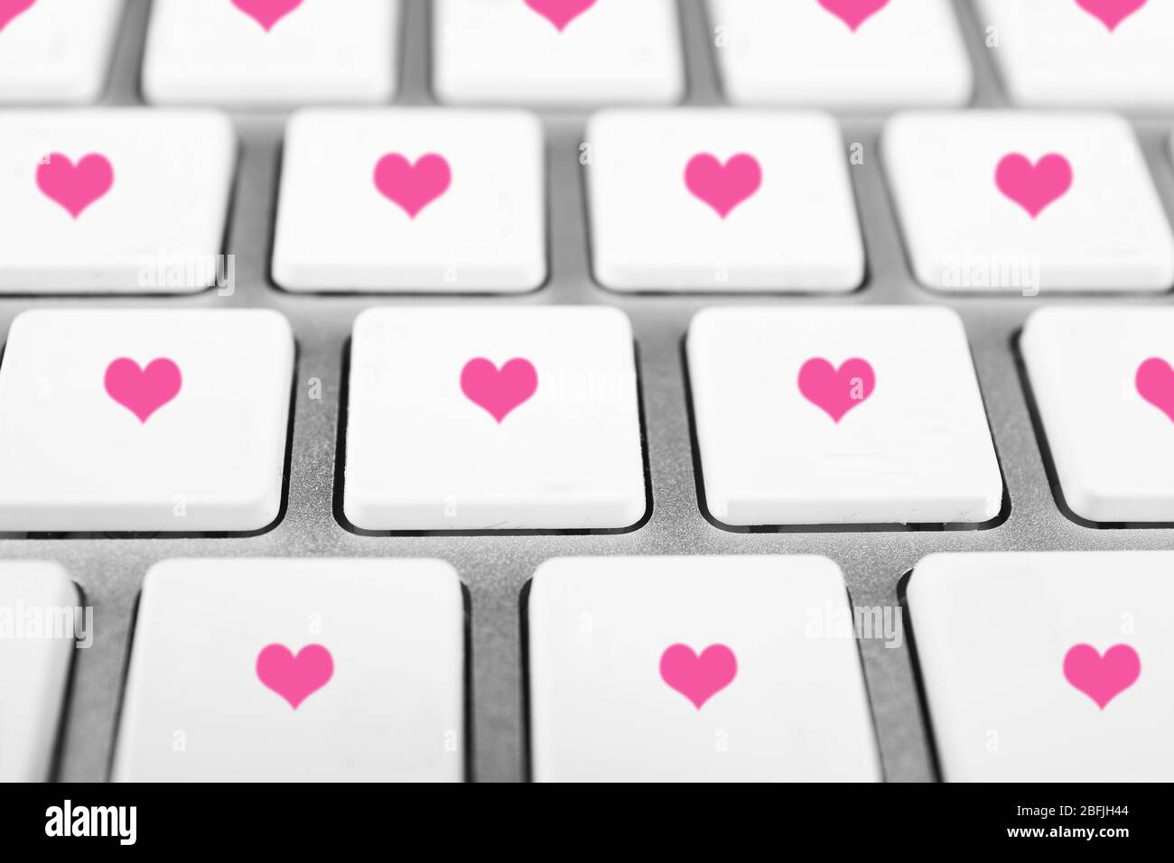 Close up of laptop keyboard with hearts icons Stock Photo - Alamy