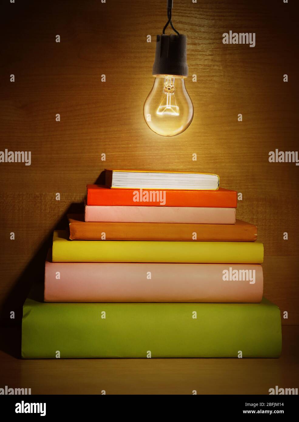 Lightbulb and books Stock Photo - Alamy