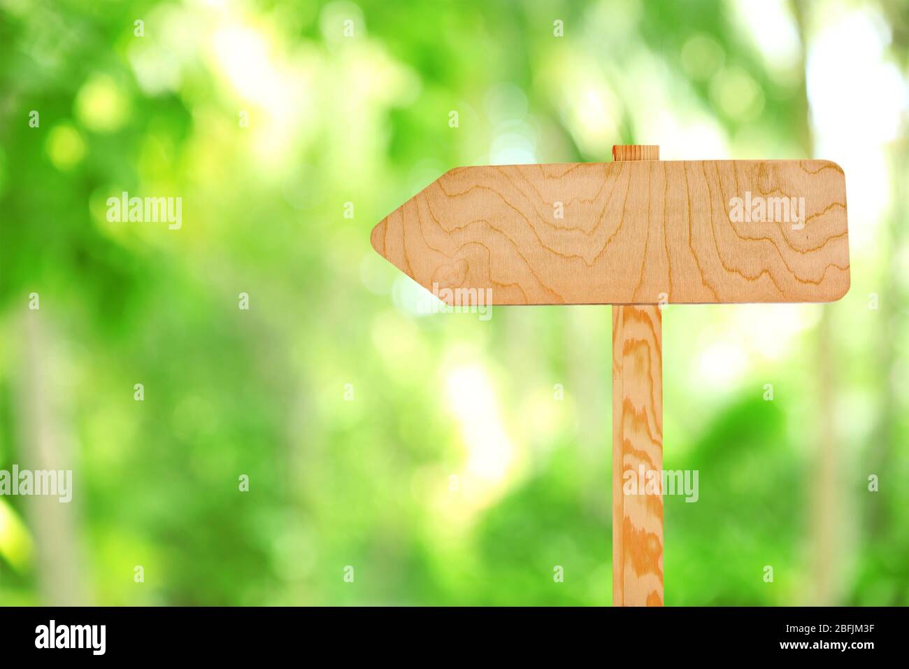 Wooden sign arrow on nature background Stock Photo - Alamy